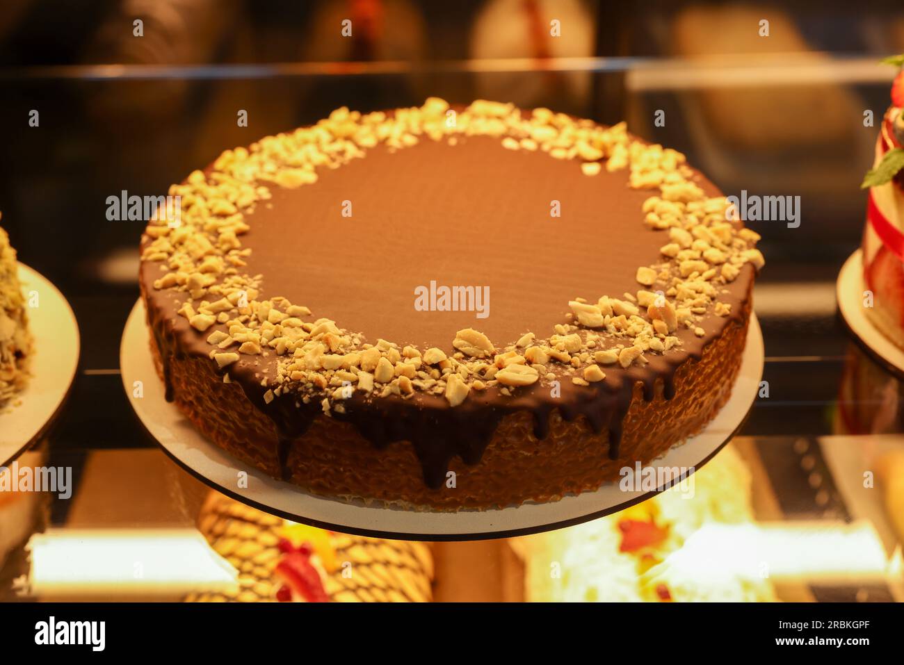 Delicious wafer cake with condensed milk, chocolate and nuts on counter ...