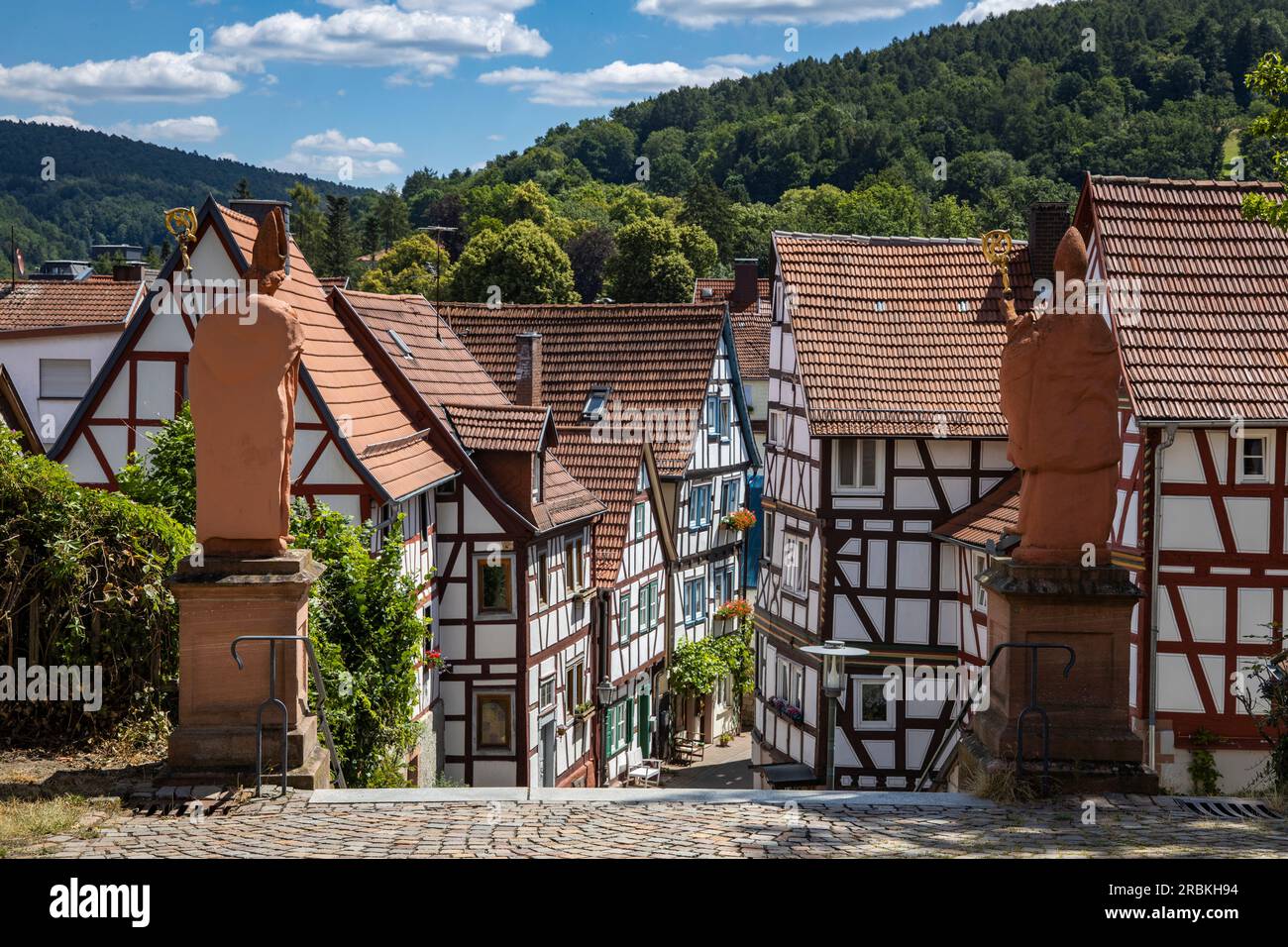 Statues at the top of a staircase with half-timbered houses in the old ...