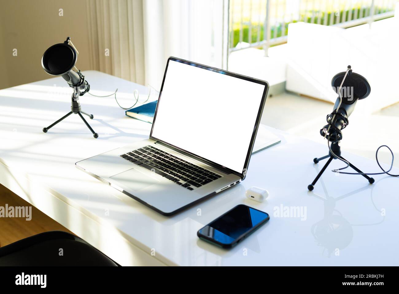 Smartphone, laptop with copy space on screen and microphone on desk at ...