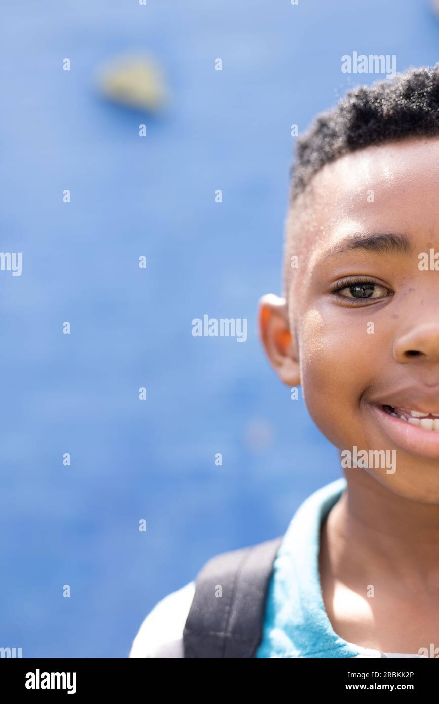 Vertical half face portrait of smiling african american boy in ...