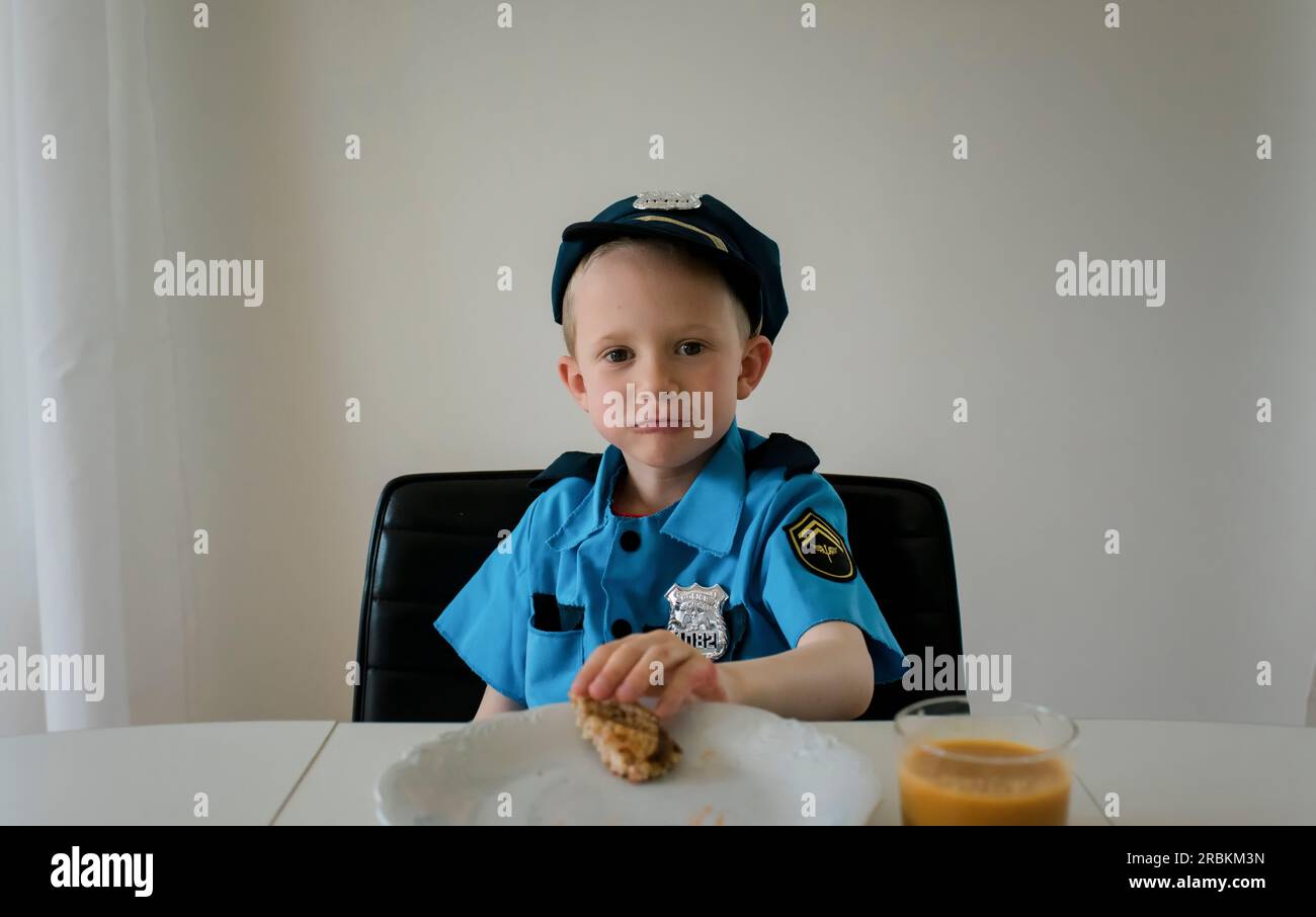young boy in fancy dress as a police officer eating breakfast Stock ...