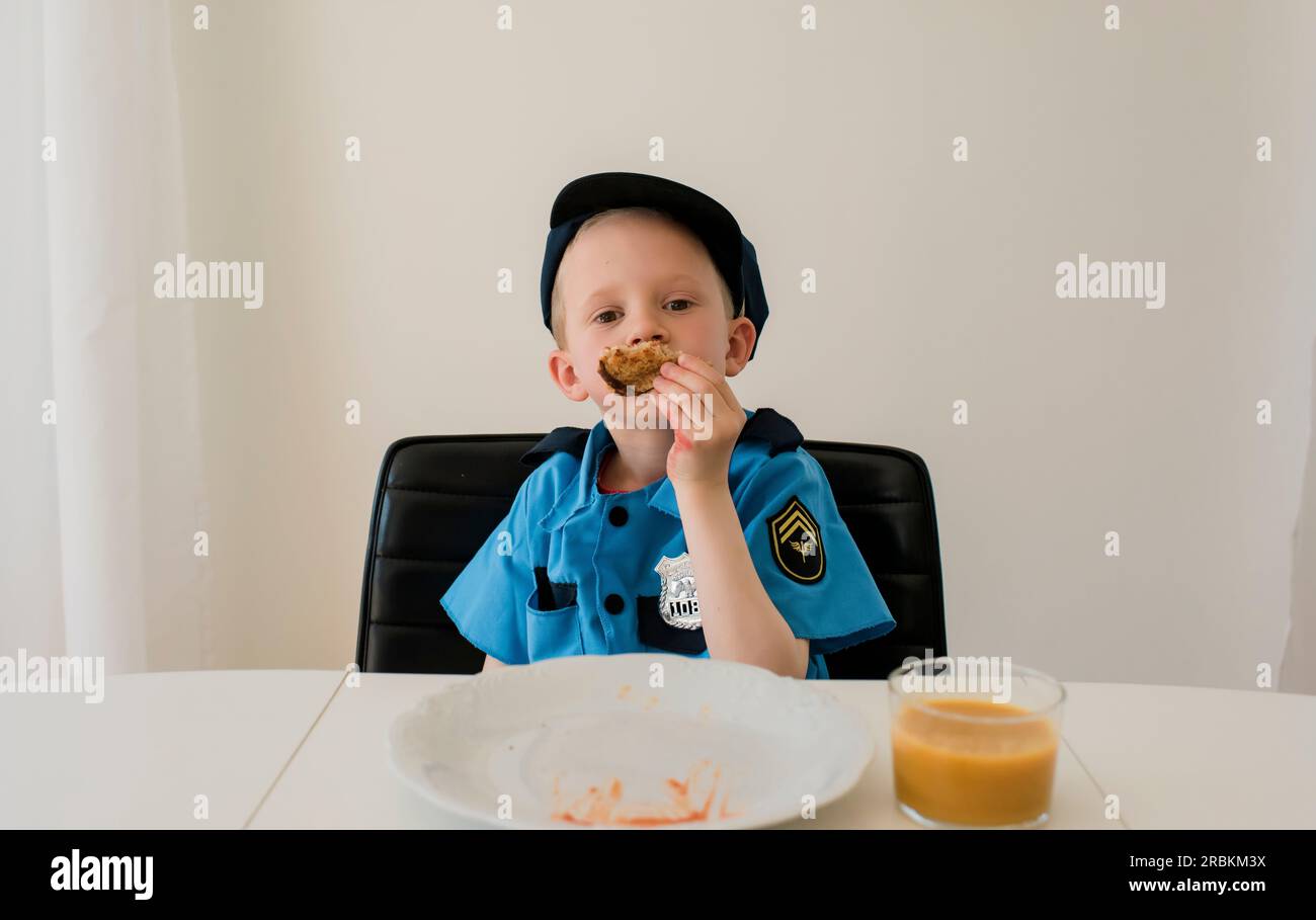 young boy in fancy dress at meal time playing with food Stock Photo - Alamy