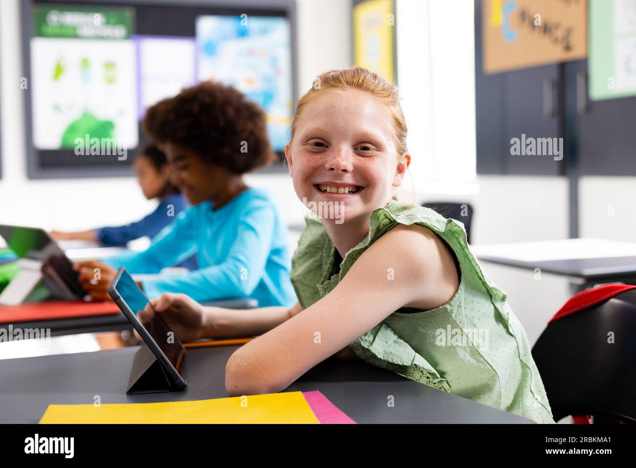 Happy diverse schoolchildren sitting at desks in school classroom Stock ...