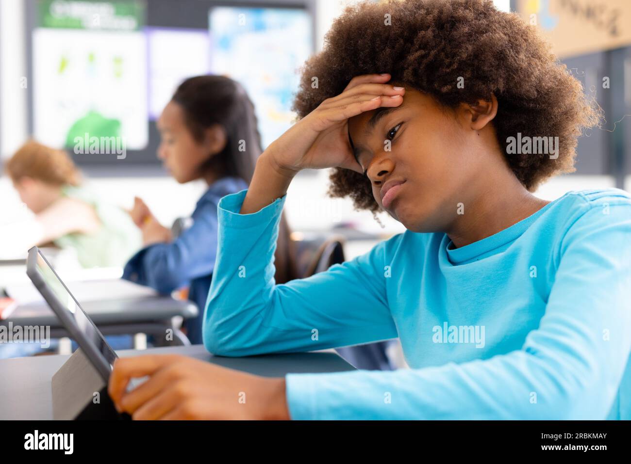Happy diverse schoolchildren sitting at desks in school classroom Stock ...