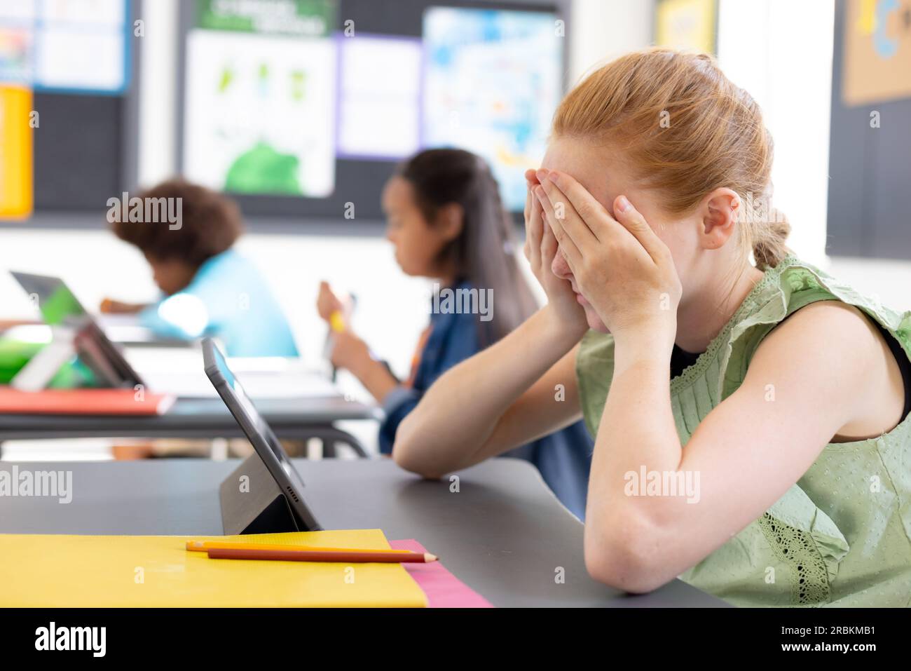 Happy diverse schoolchildren sitting at desks in school classroom Stock ...