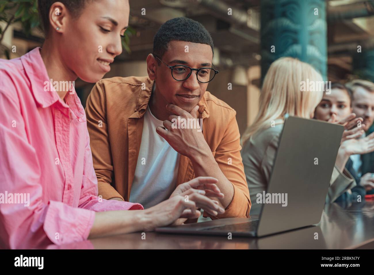Group of coworkers working together and talking at modern office ...