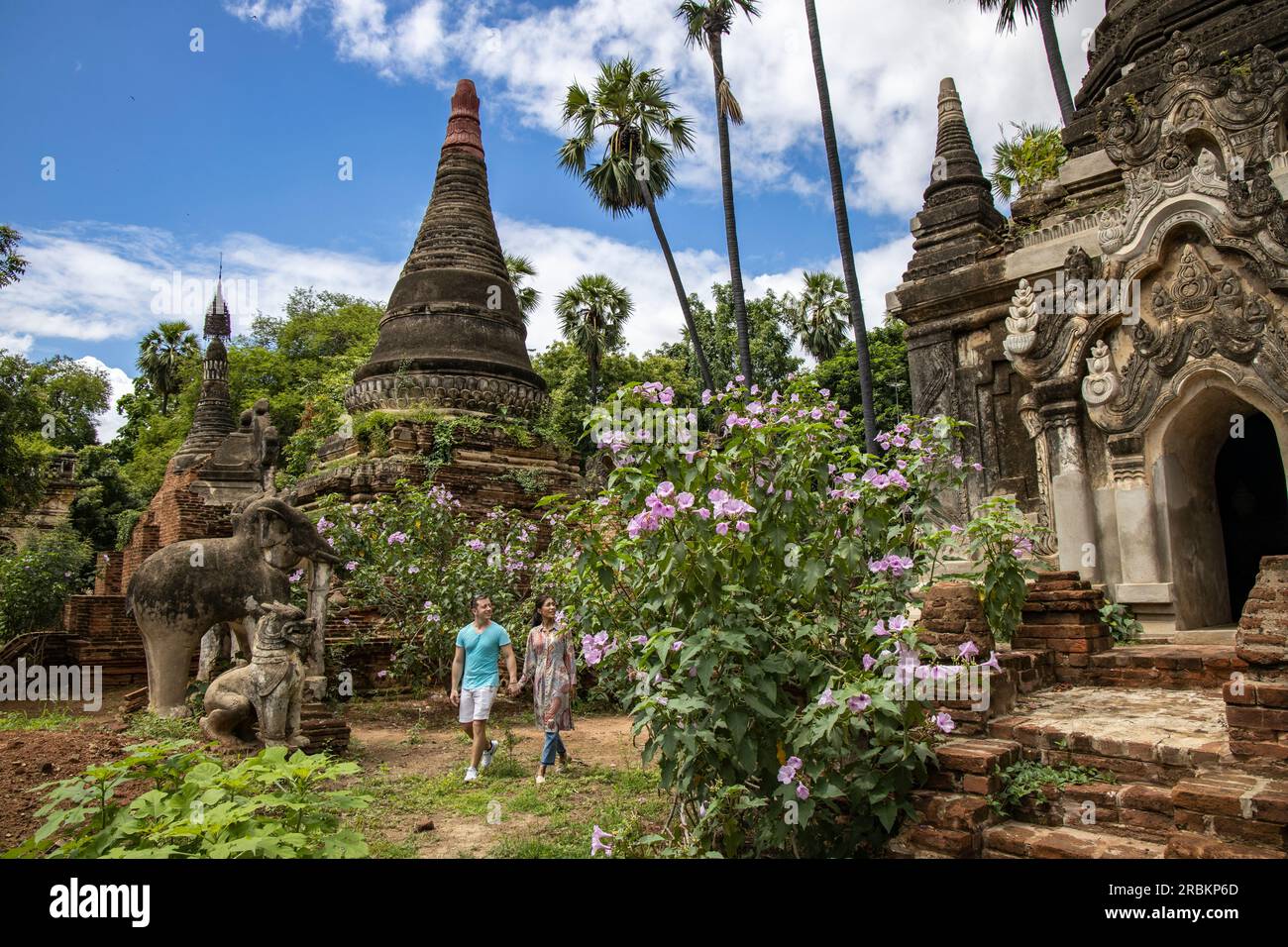 Couple strolling through area of ancient statues and pagodas dating ...