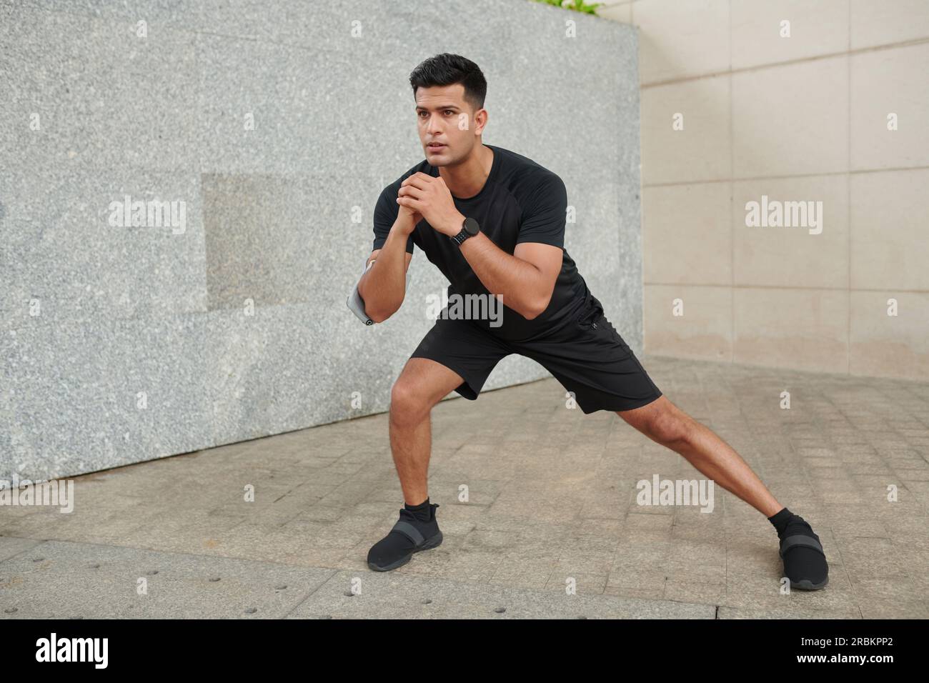Fit man doing side lunges when working out outdoors Stock Photo - Alamy