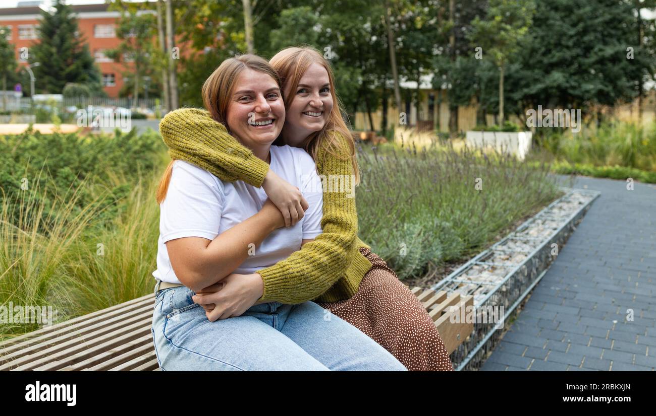 Two happy young women friend hugging outdoors at park. Close up Stock ...