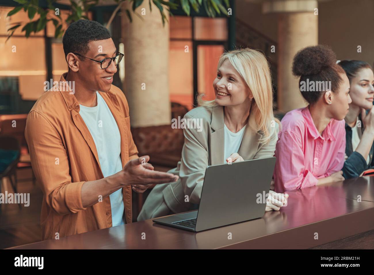 Group of coworkers working together and talking at modern office ...
