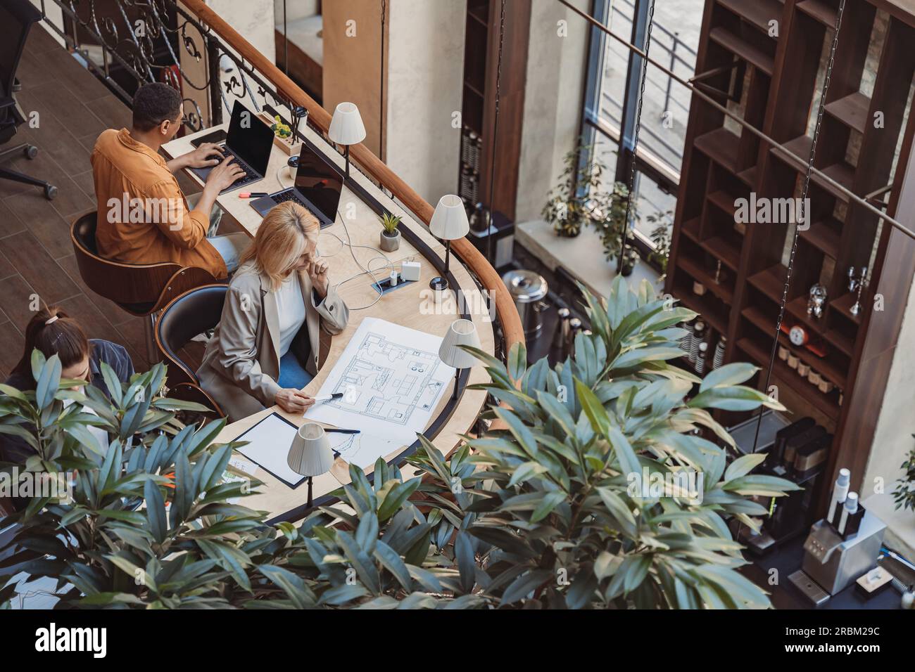 Top view of two business people working in cozy coworking separately ...