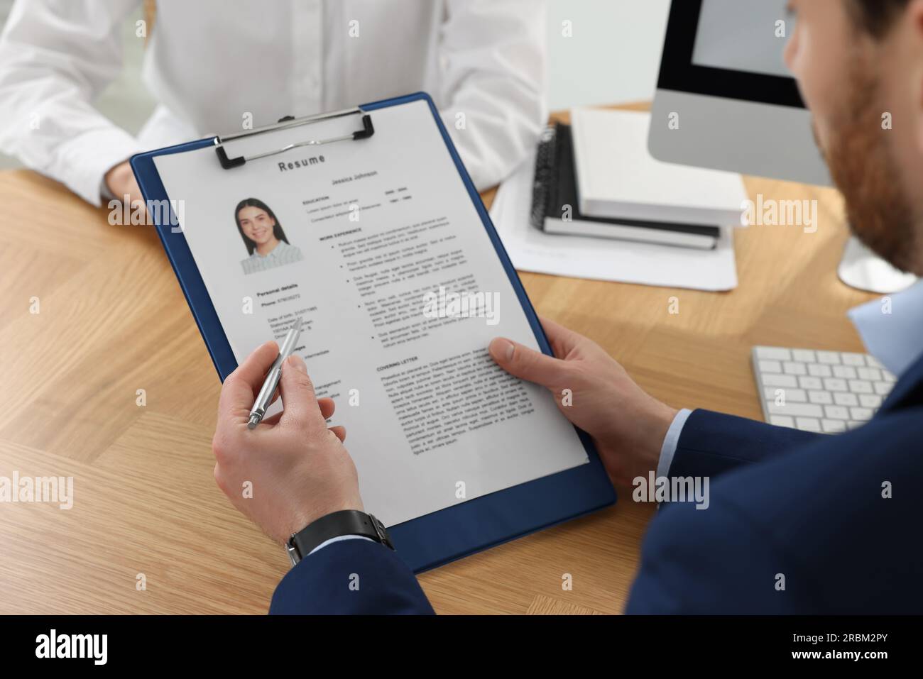 Human resources manager reading applicant's resume in office, closeup ...