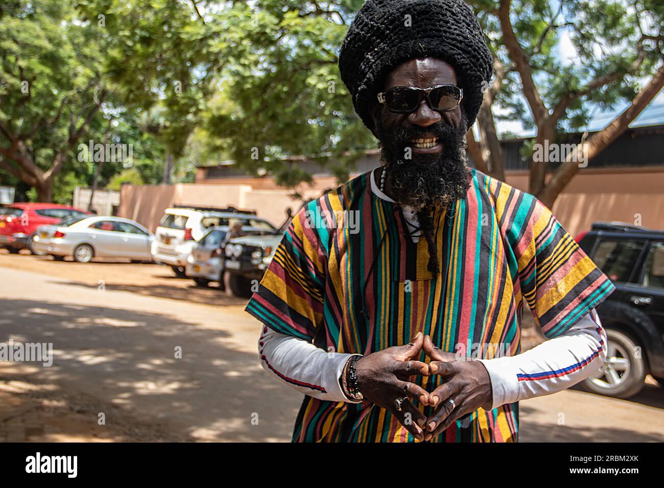 Happy Rastafari person wearing colorful clothing and wool hat, having ...