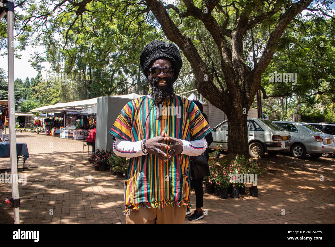 Happy Rastafari person wearing colorful clothing and wool hat, having ...