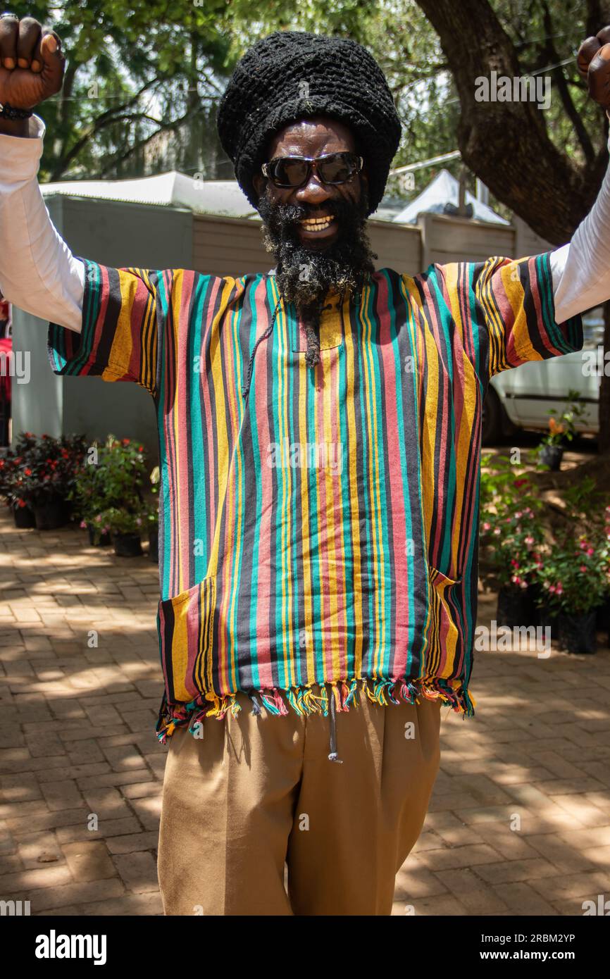 Happy Rastafari person wearing colorful clothing and wool hat, having ...