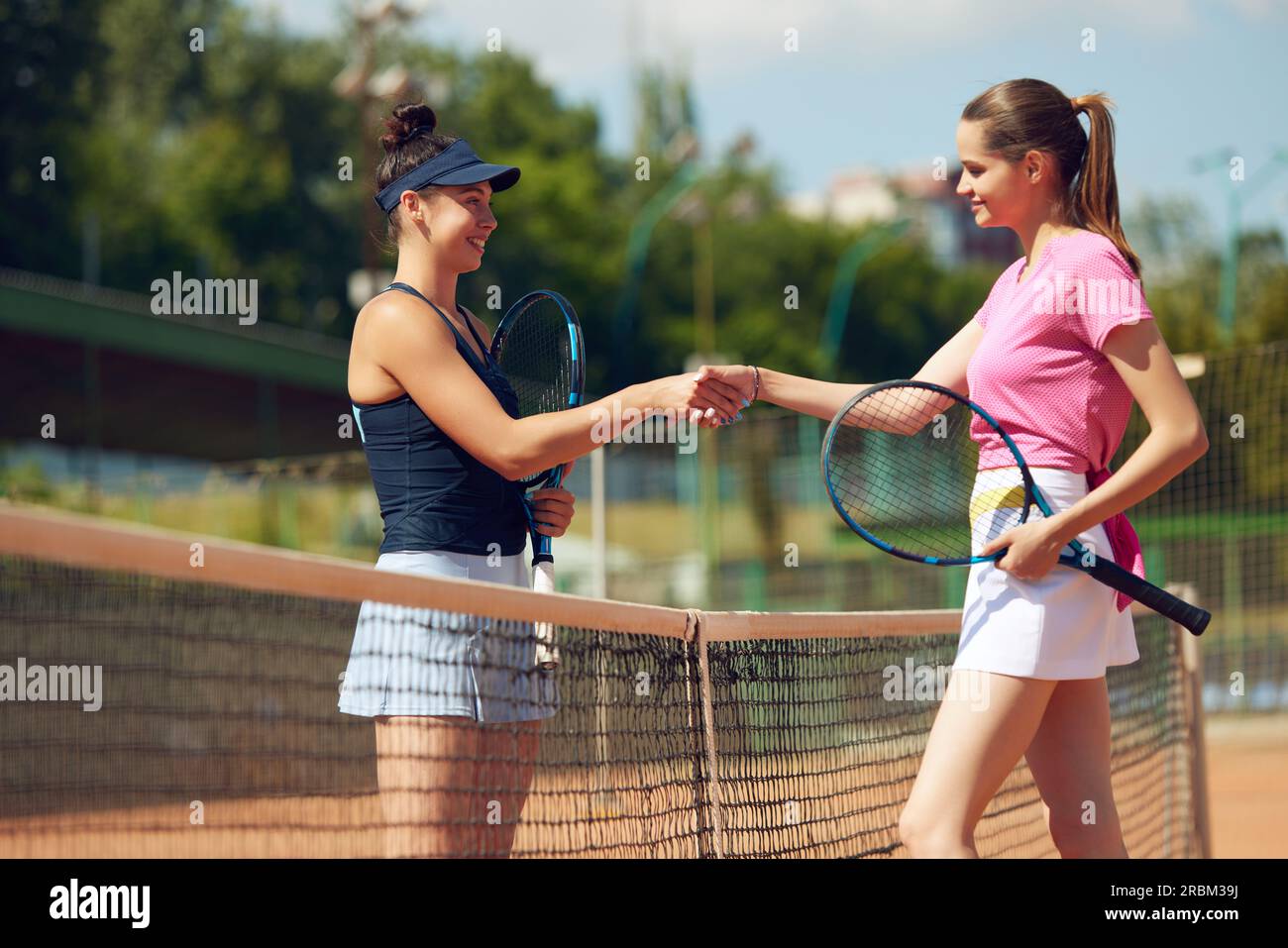 Young girls, athletes shaking hands before game session. Playing tennis ...
