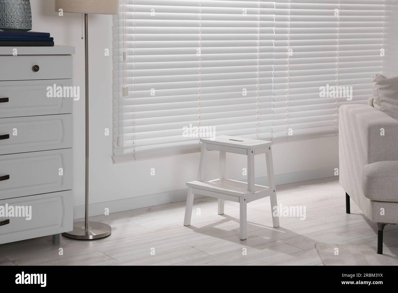 White compact ladder near window at home Stock Photo - Alamy