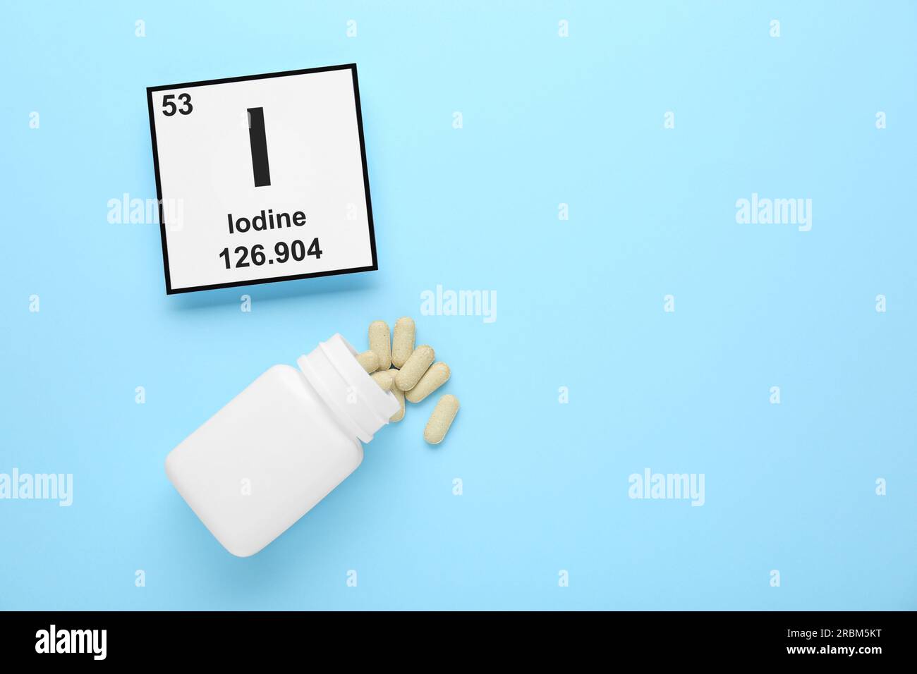 Plastic jar and iodine pills on light blue background, flat lay. Space ...
