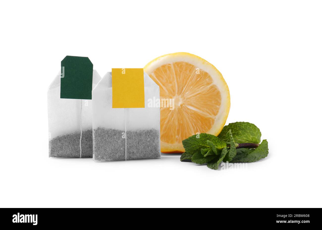 New tea bags with labels, lemon and mint on white background Stock ...