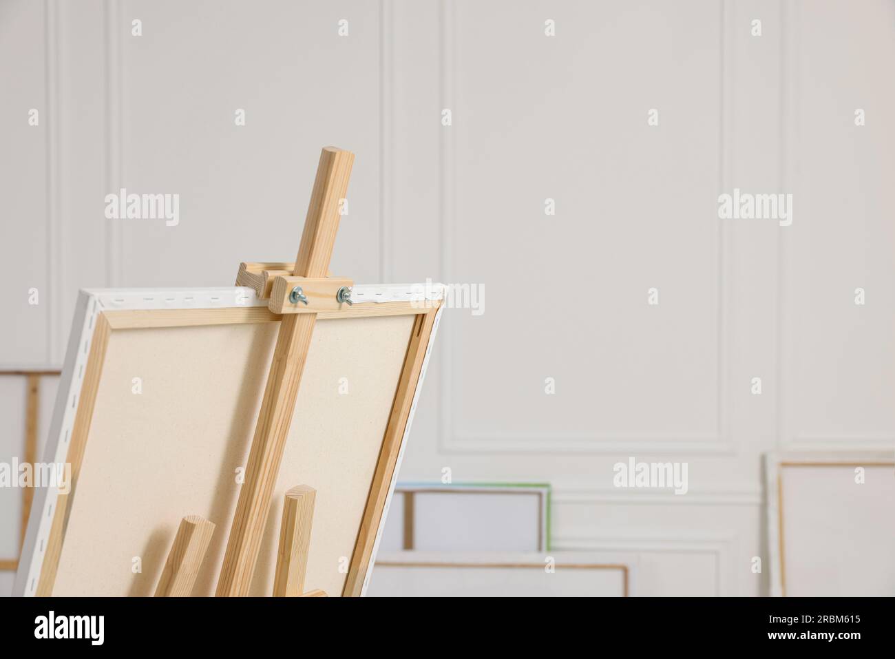 Wooden easel with canvas in artist's studio, space for text Stock Photo ...