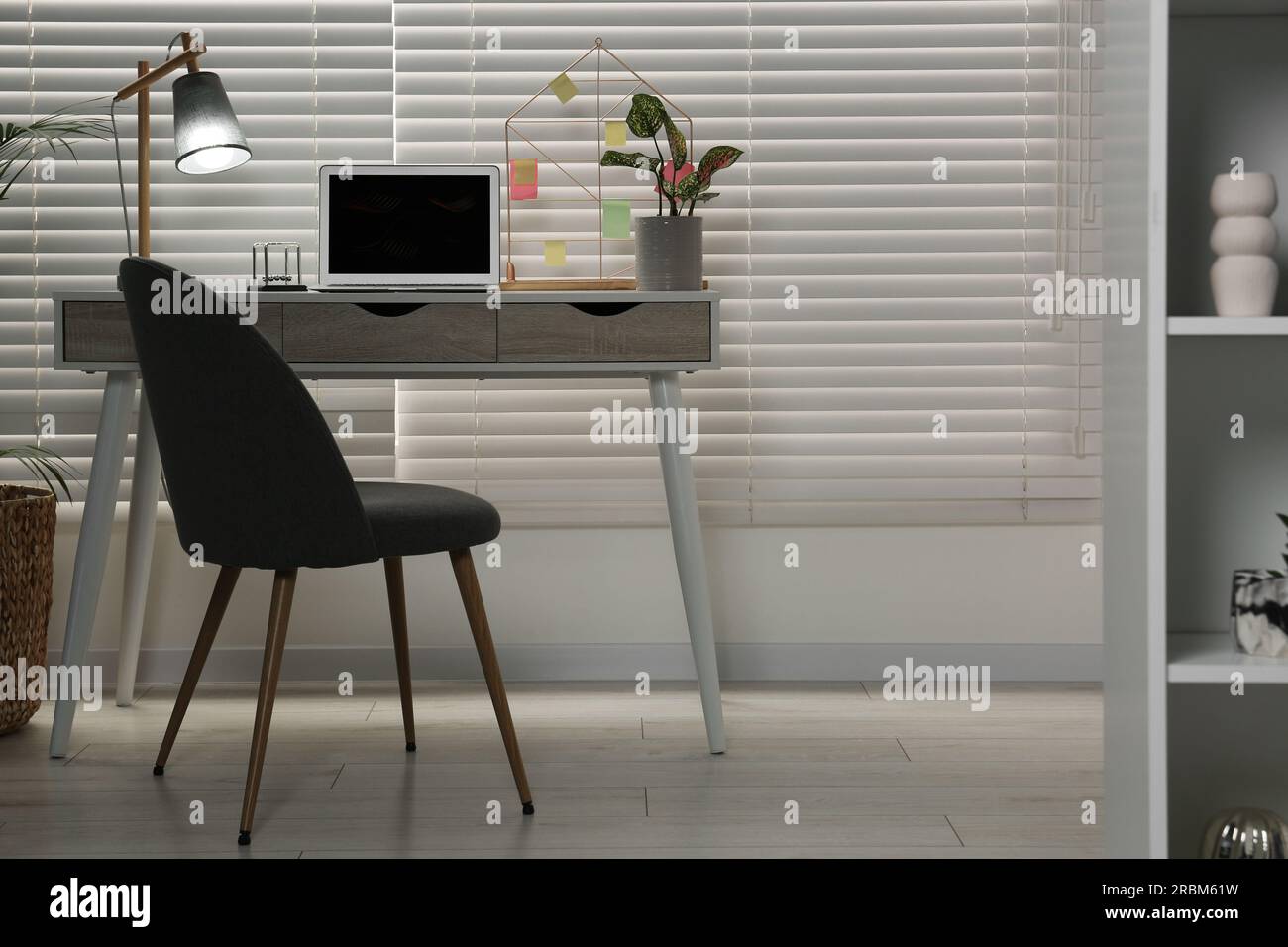 Cozy workspace with laptop, desk and comfortable chair at home. Stylish ...