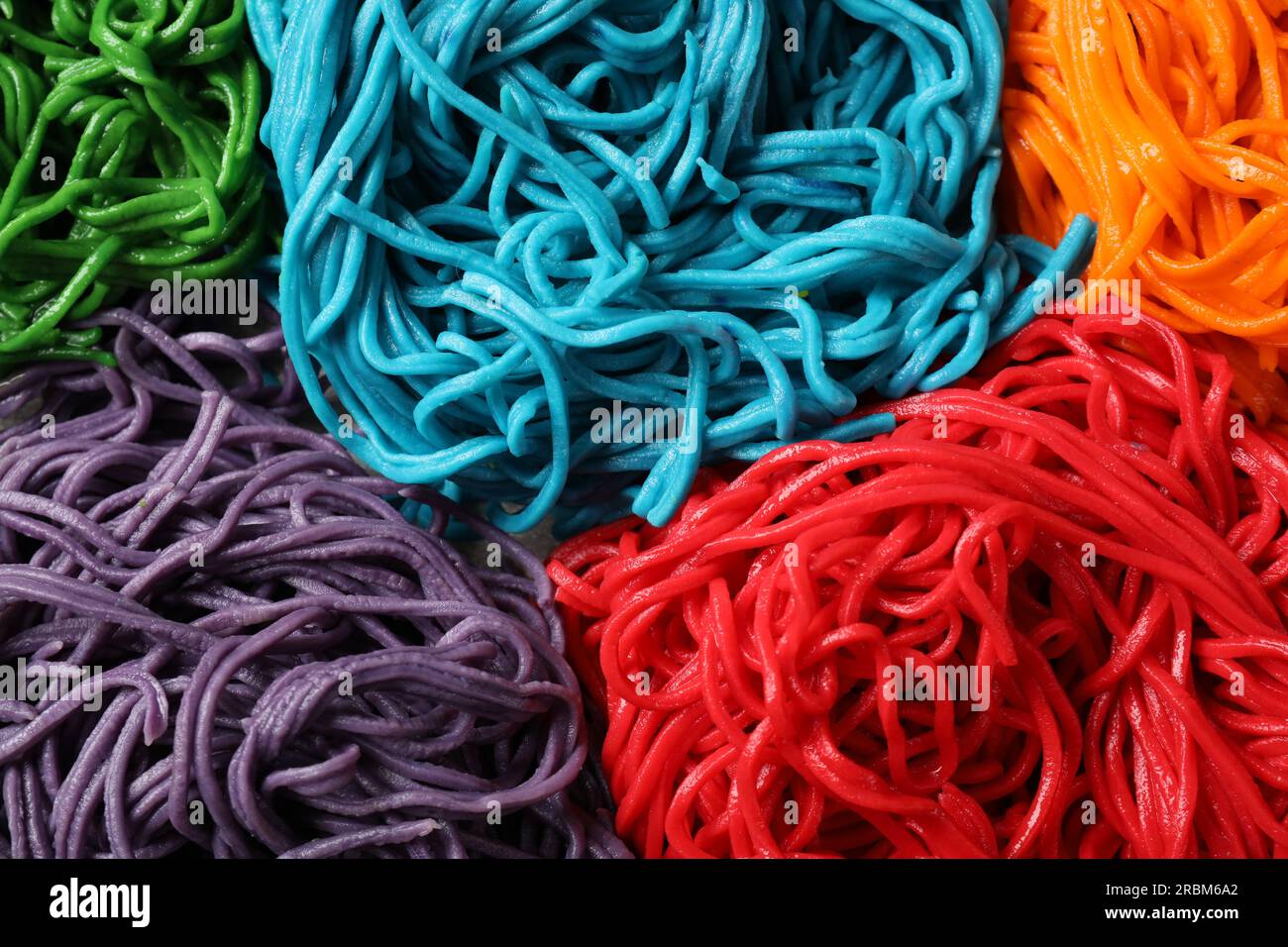 Rolled spaghetti painted with different food colorings as background ...
