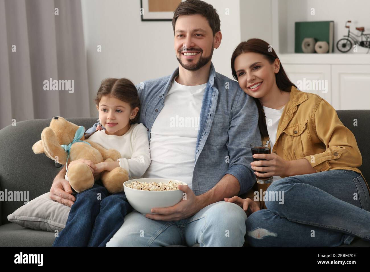 Happy family watching TV on sofa at home Stock Photo - Alamy