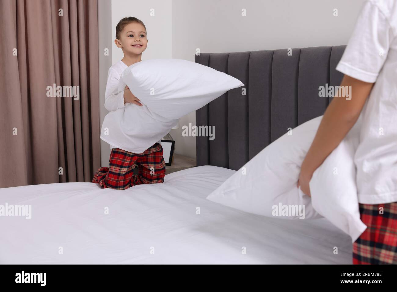 Brother and sister changing bed linens together in bedroom Stock Photo ...