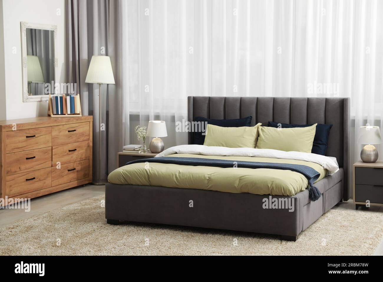 Stylish bedroom interior with large comfortable bed Stock Photo - Alamy