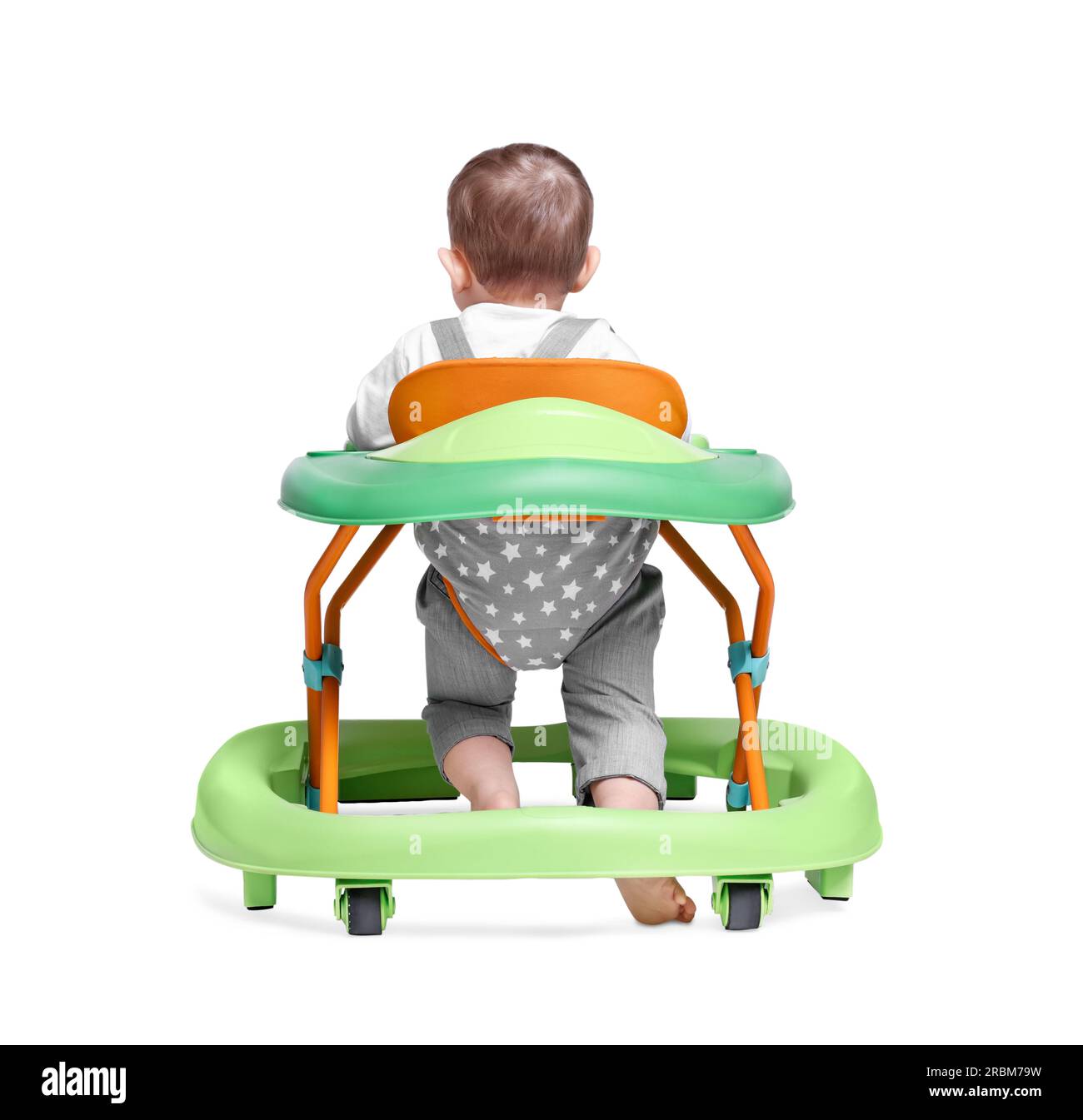 Cute little boy making first steps with baby walker on white background ...