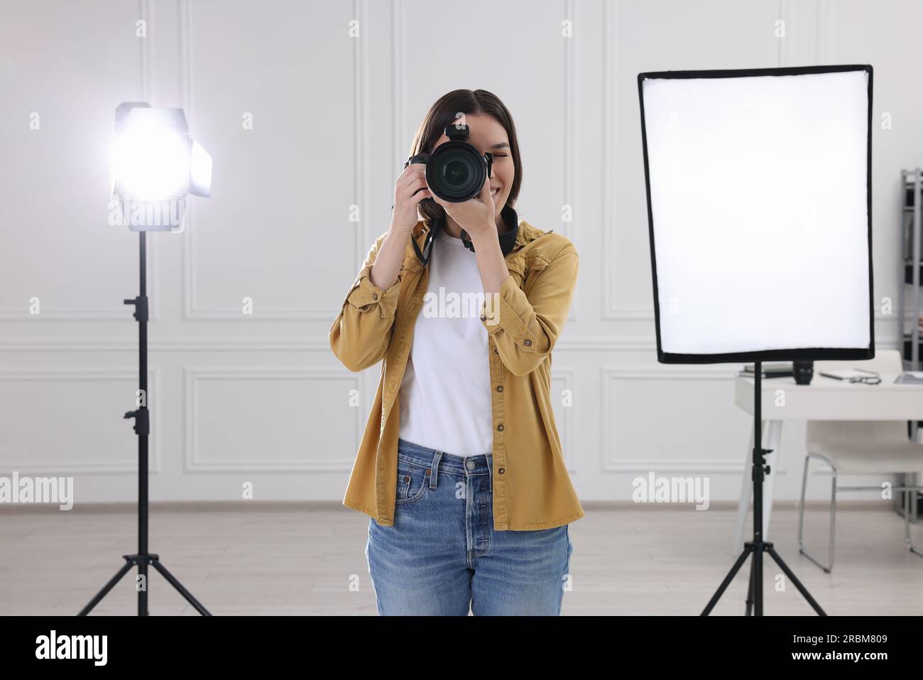 Professional photographer taking picture in modern photo studio Stock ...