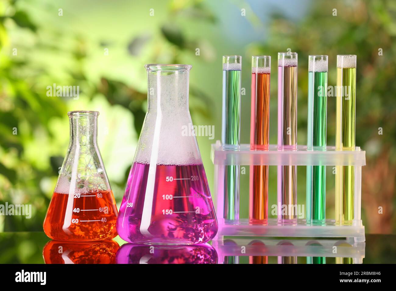 Laboratory glassware and test tubes with colorful liquids on glass ...