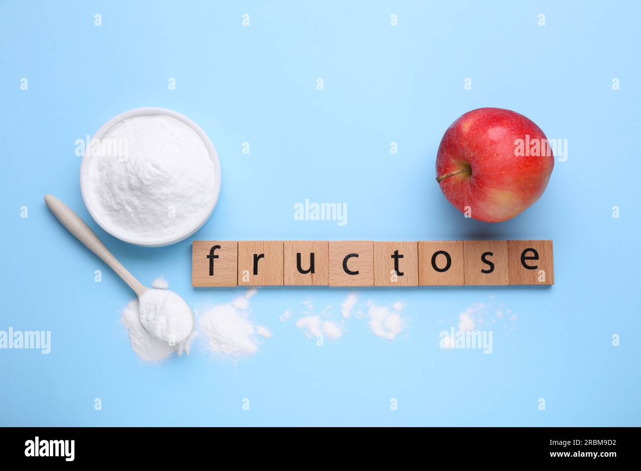 Word Fructose made of wooden cubes, powder and fresh apple on light ...