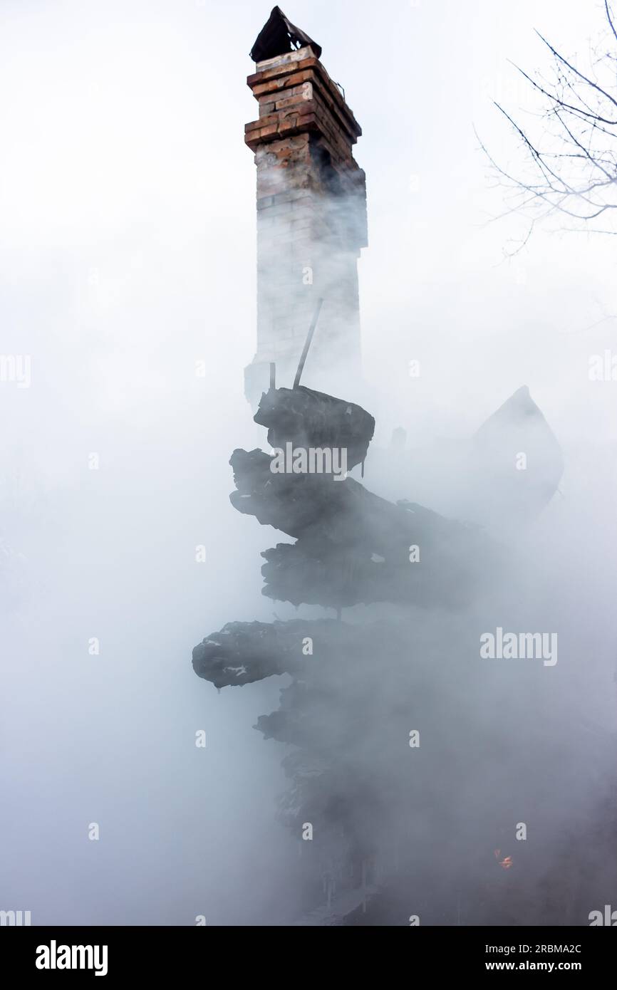 Remains of a house after a fire. The brick chimney of the stove and the ...