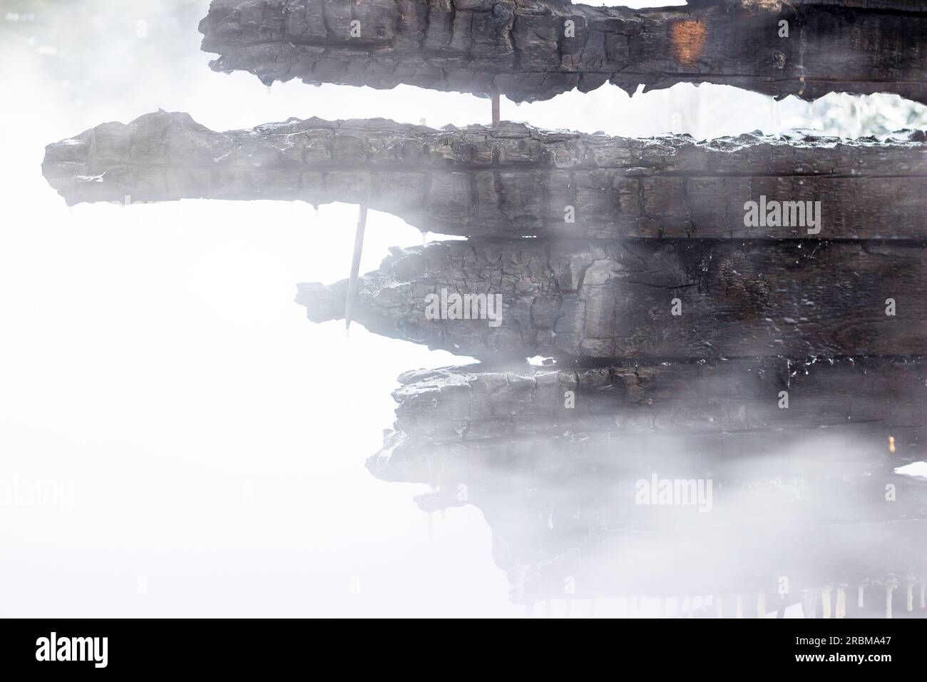 Charred wooden walls of a house after a fire. Burnt boards in a burnt ...