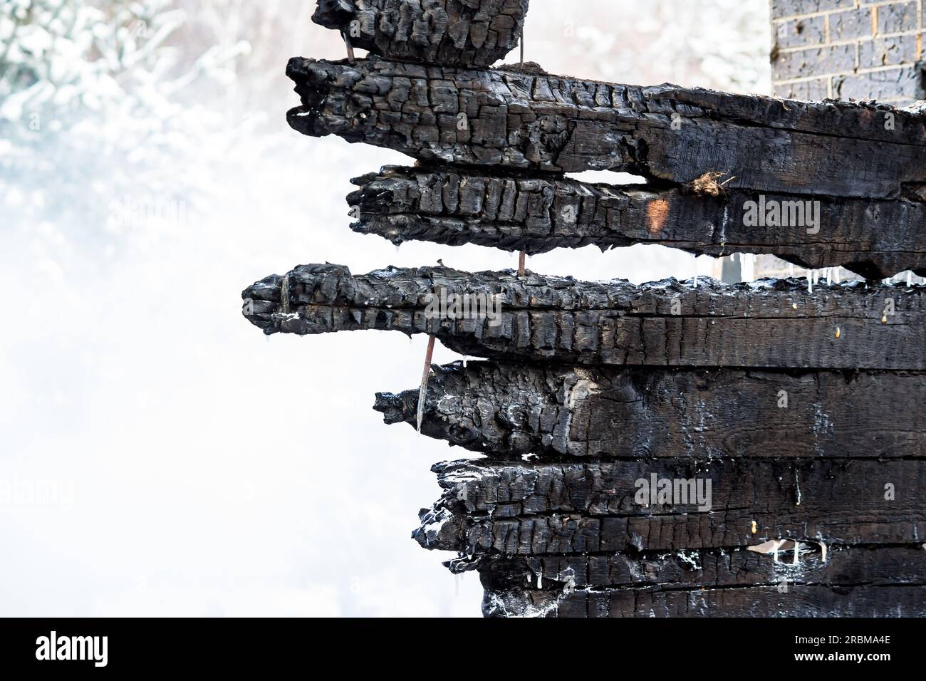 Charred wooden walls of a house after a fire. Burnt boards in a burnt ...