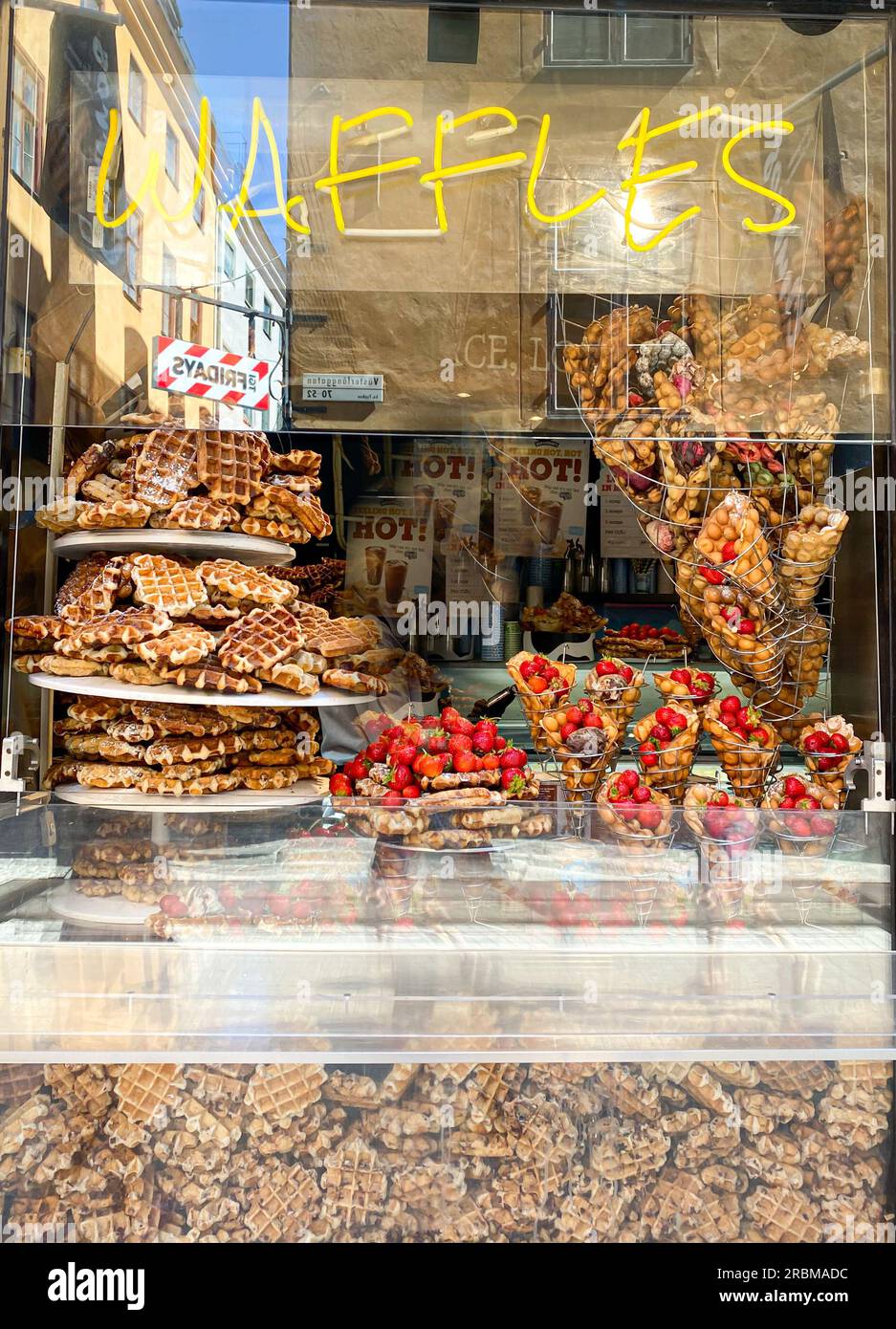 A lot of traditional Belgian waffles topped with fruit display in a ...