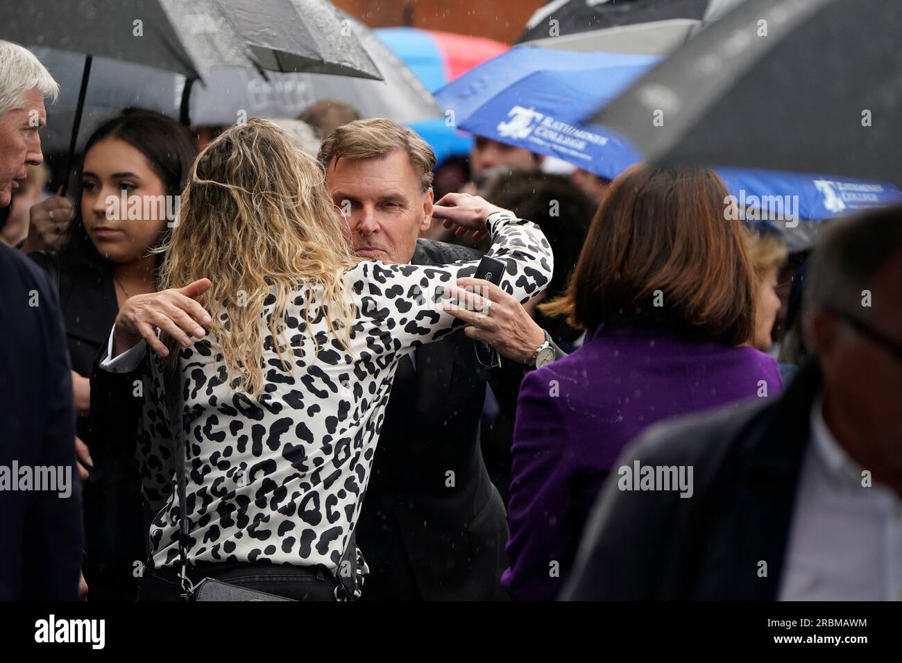 Max Wall's father Niall Wall embraces a mourner attending the funeral ...