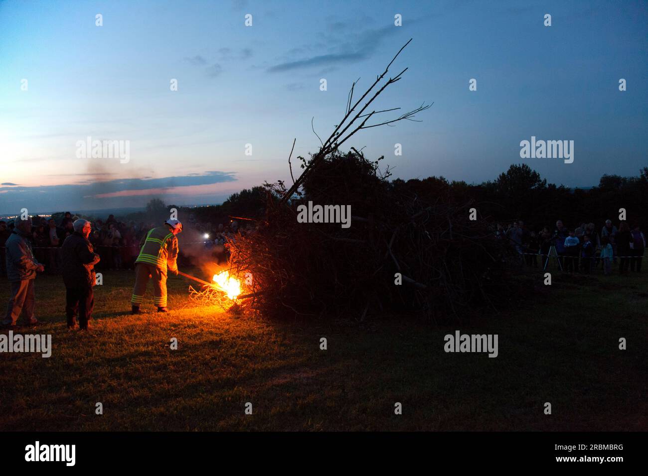 A huge crowd watches a fireman light a beacon in celebration of the ...