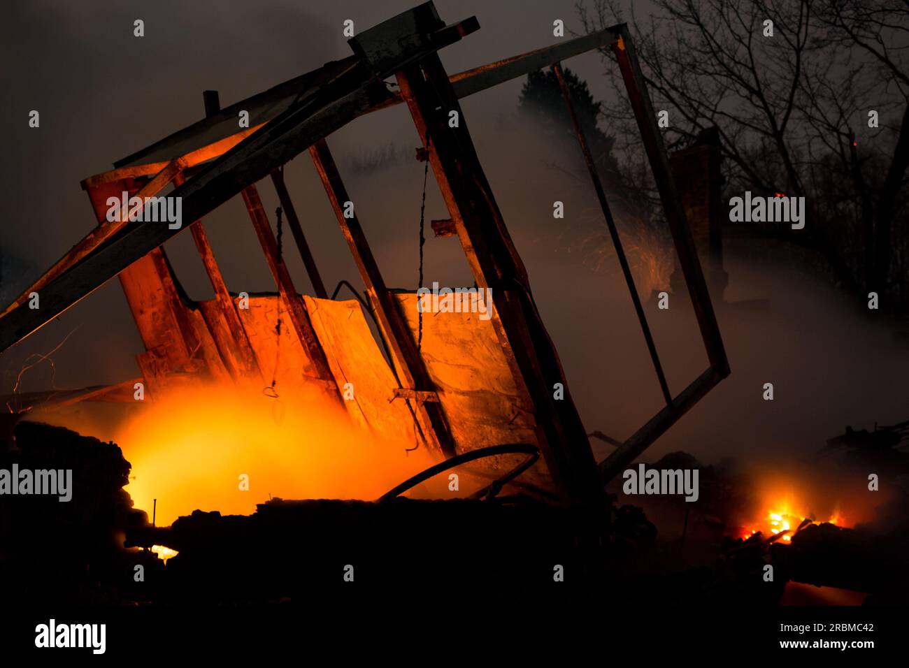 Fire in the private sector. Burning building, night view. Burning out ...