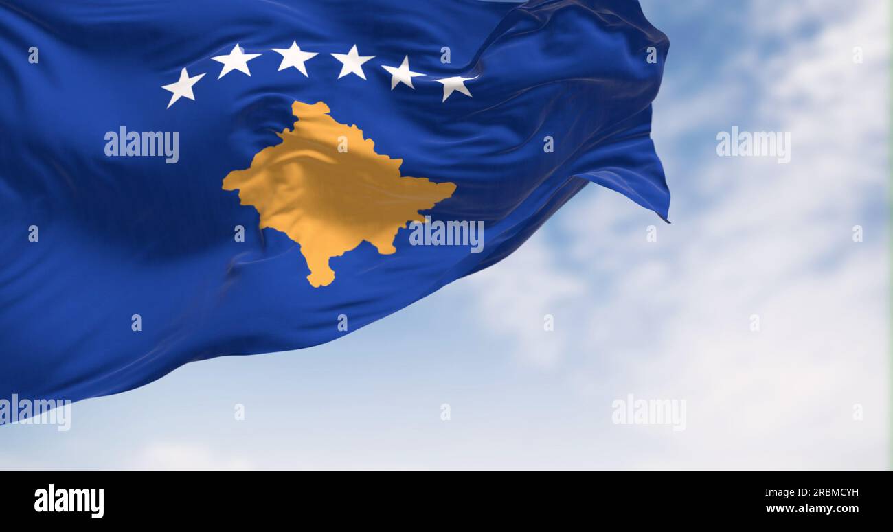 National flag of Kosovo waving in the wind on a clear day. Blue with a ...