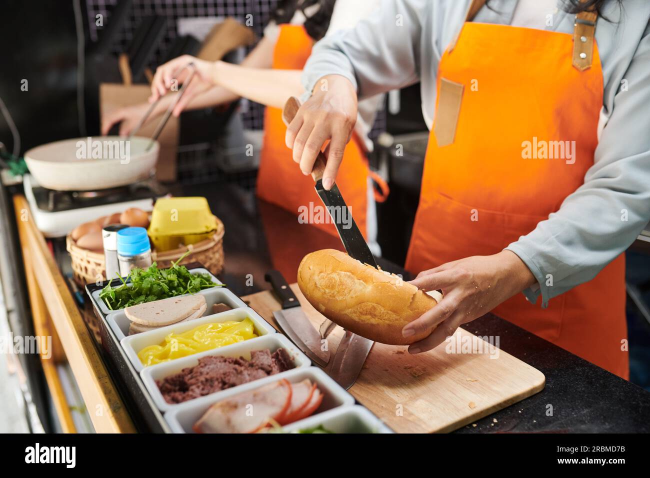 Cropped image of cooks cutting buns and putting in ingredients Stock ...