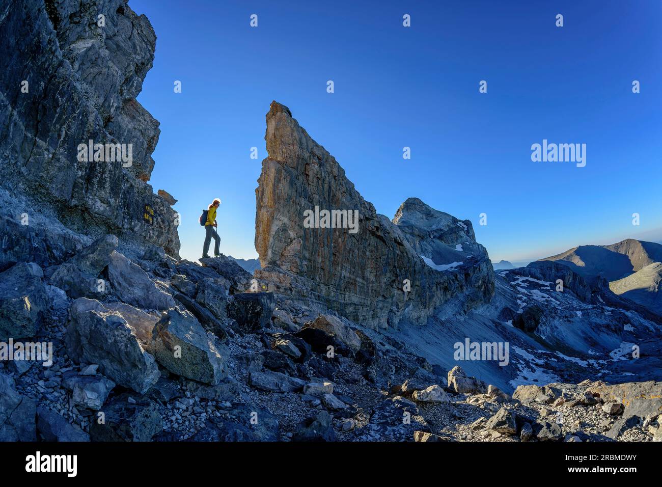 Woman hiking stands in front of the Rolandsbrecher, Breche de Roland ...