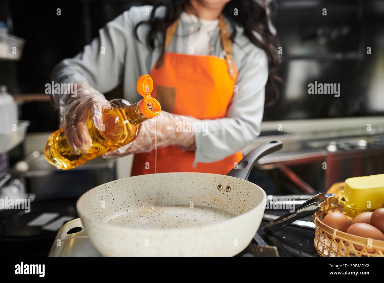 Food truck cook pouring vegetable oil in saucepan Stock Photo - Alamy