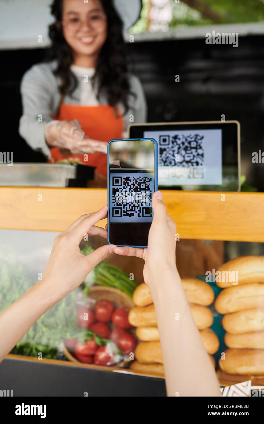 Customer scanning qr code with smartphone to read menu or pay for order ...