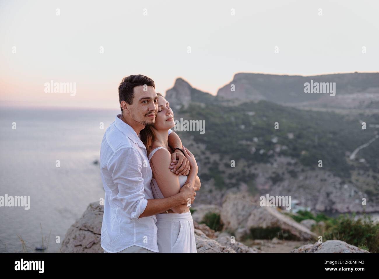 Beautiful young loving couple man of Middle Eastern appearance and a Caucasian woman hug, kiss ...