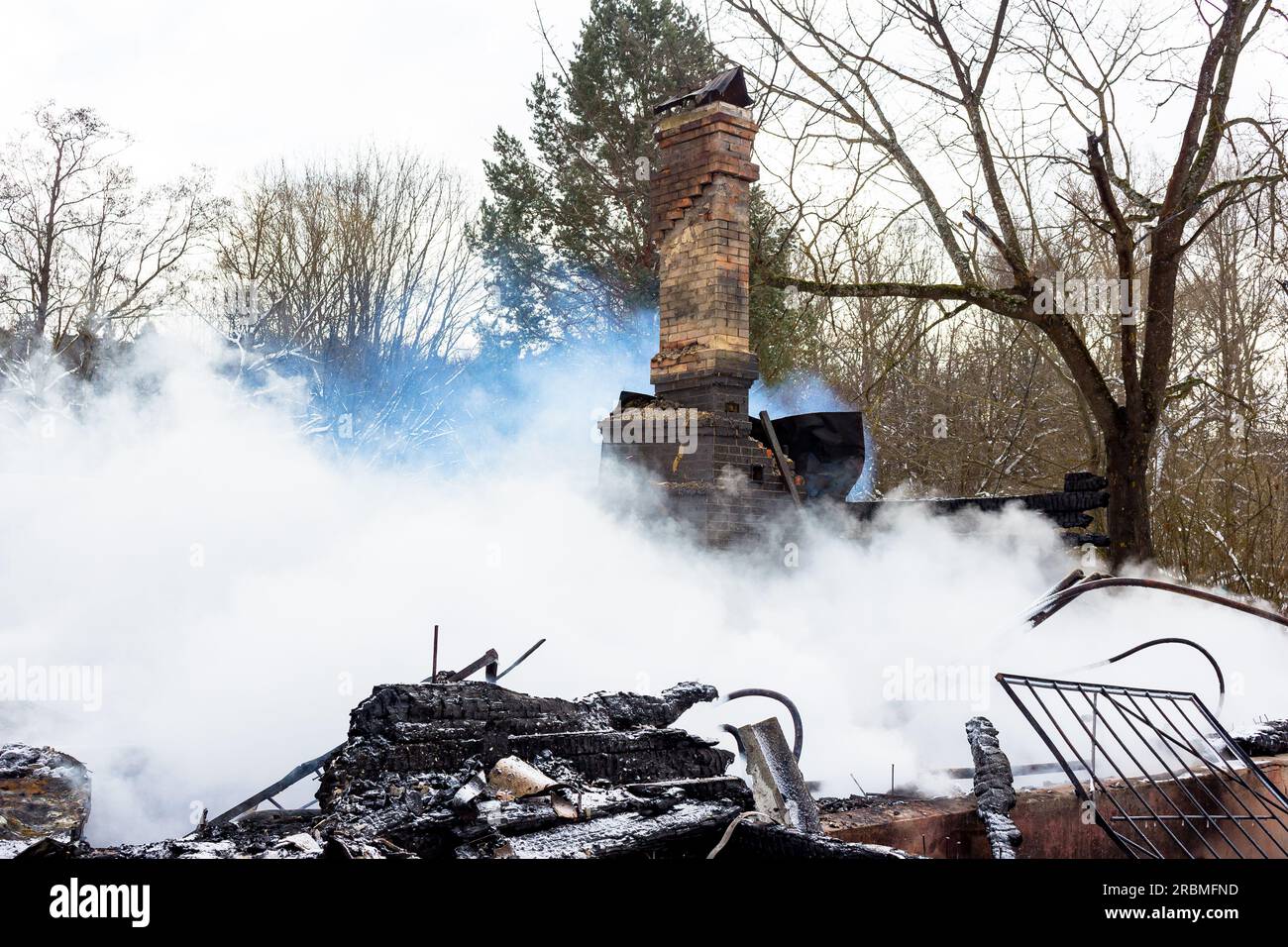 Smoke on the ashes, brick chimney in smoke after a fire in a wooden ...