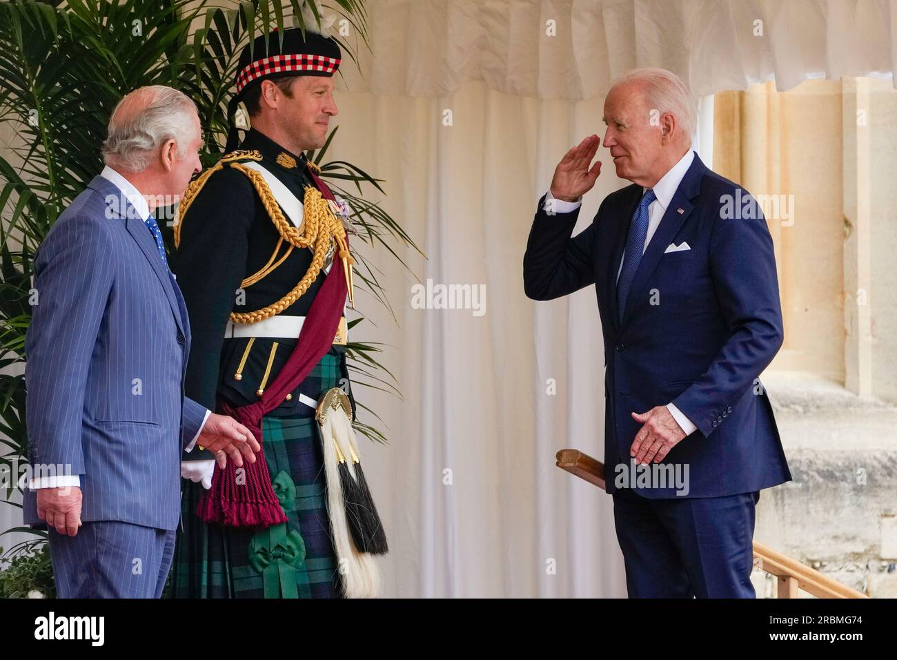US President Joe Biden salutes while attending along with Britain's ...