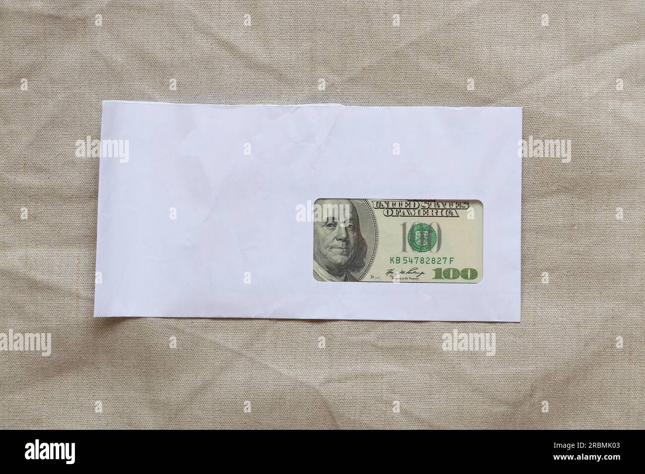 White envelope and one hundred dollars lie in an envelope on an ...