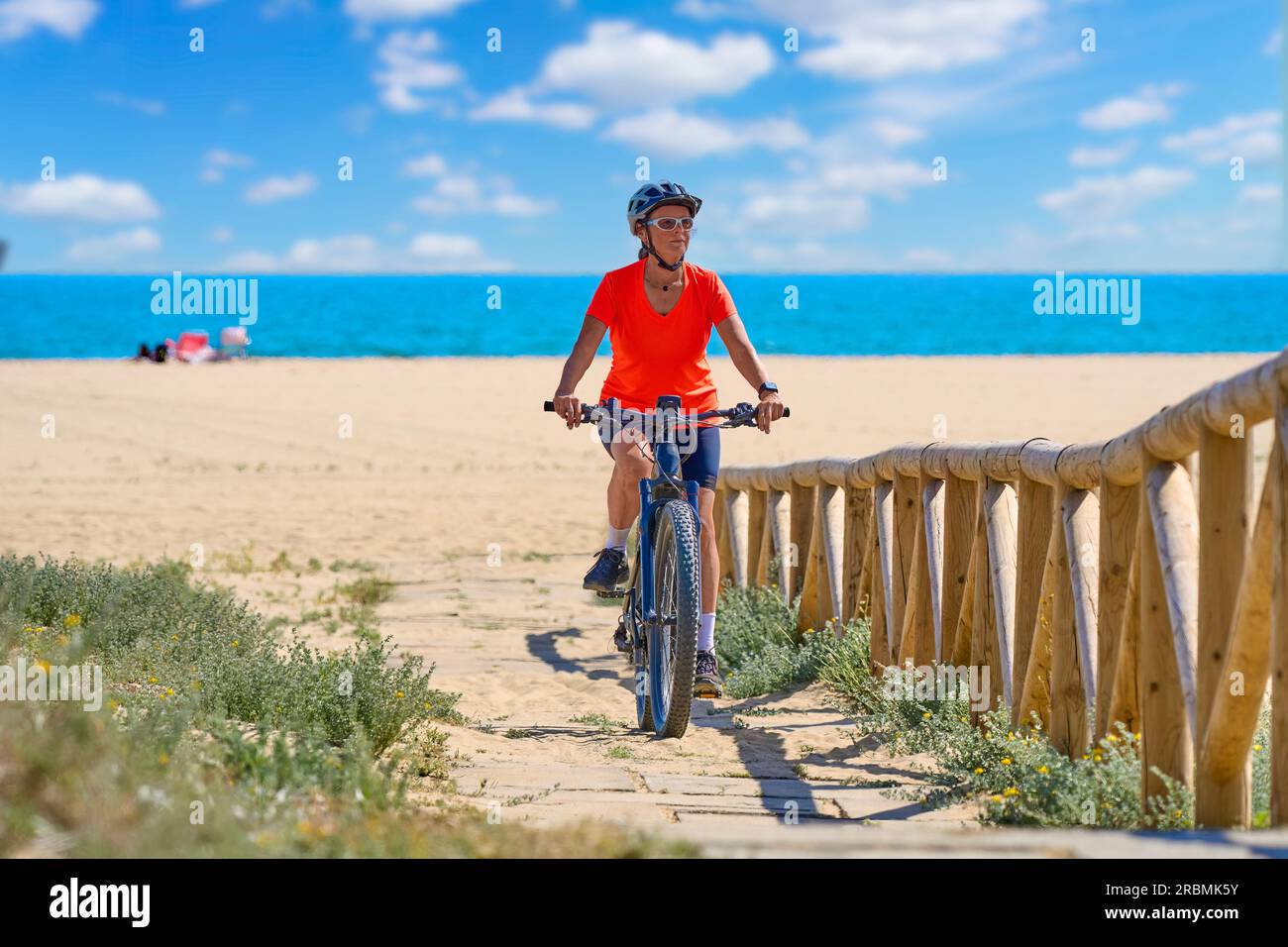 beautiful senior woman with her electric mountain bike at the golden ...